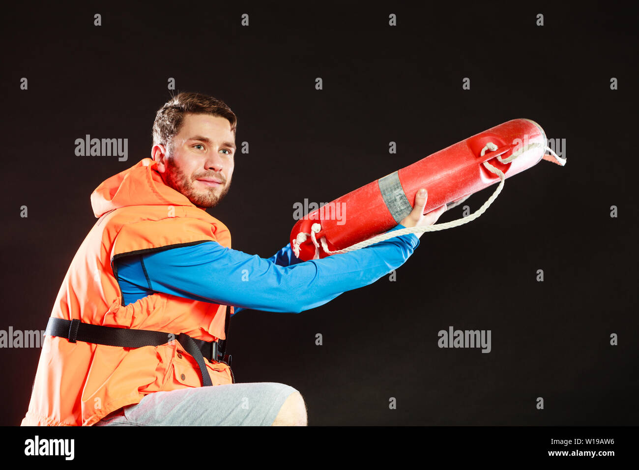 Lifeguard in life vest jacket throwing ring buoy lifebuoy. Man ...
