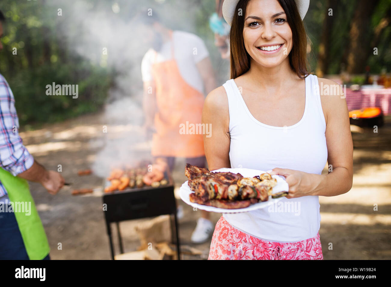 Friends having a barbecue party in nature while having fun Stock Photo ...