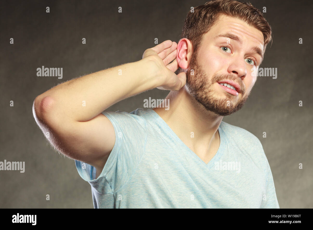 Gossip man eavesdropping with hand to ear. Guy overhearing listening to ...