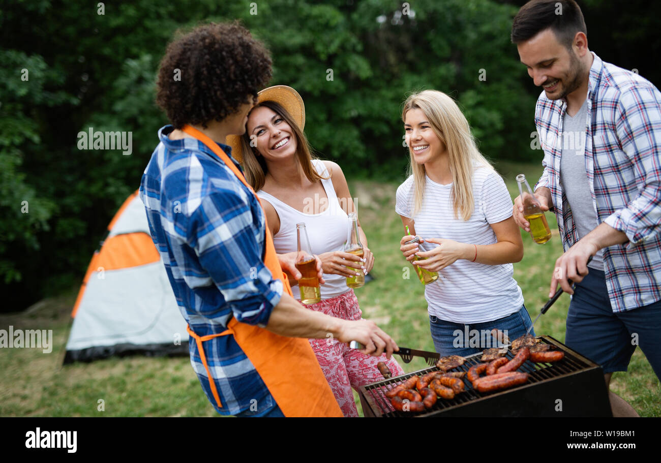Friends making barbecue and having lunch in the nature Stock Photo - Alamy