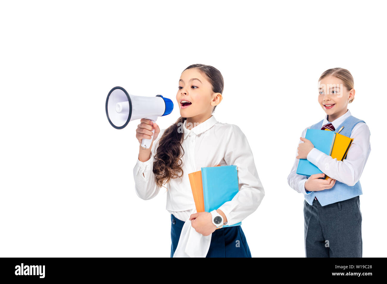 schoolgirls in formal wear holding books and shouting in mouthpiece ...