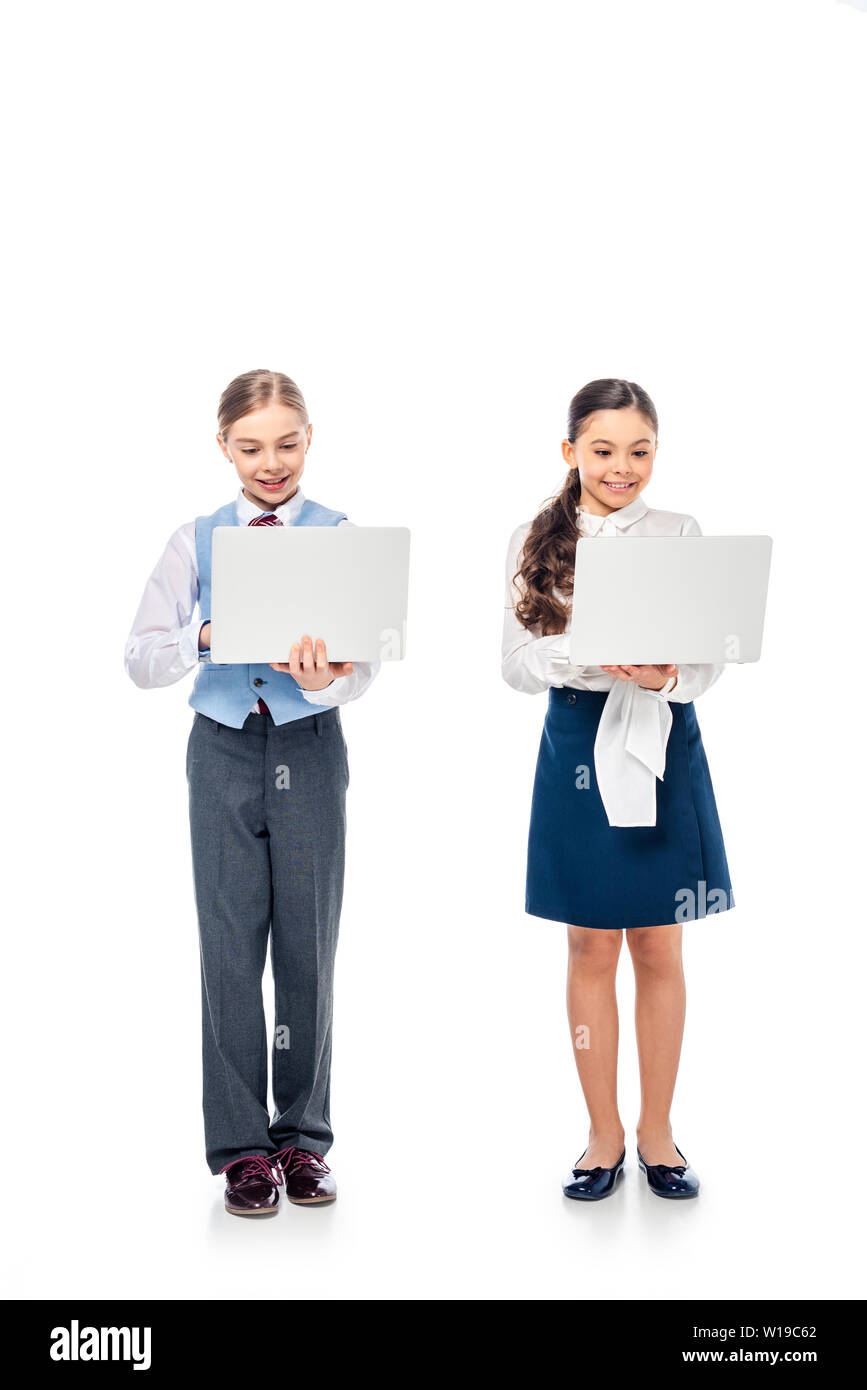 smiling schoolgirls in formal wear using laptops On White Stock Photo ...