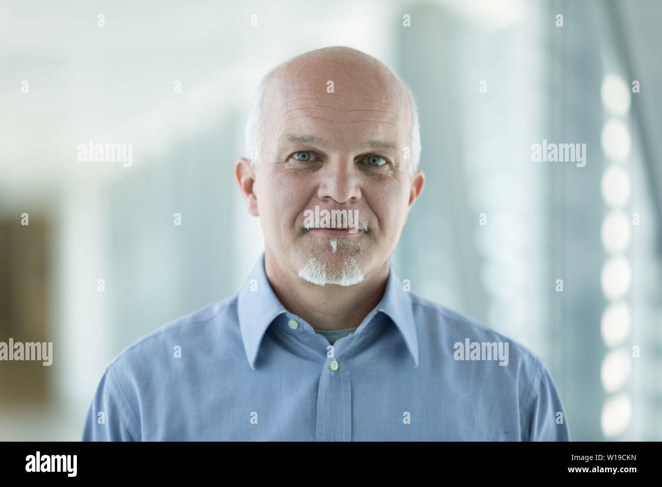 Businessman looking intently at the camera with a quiet smile as he ...