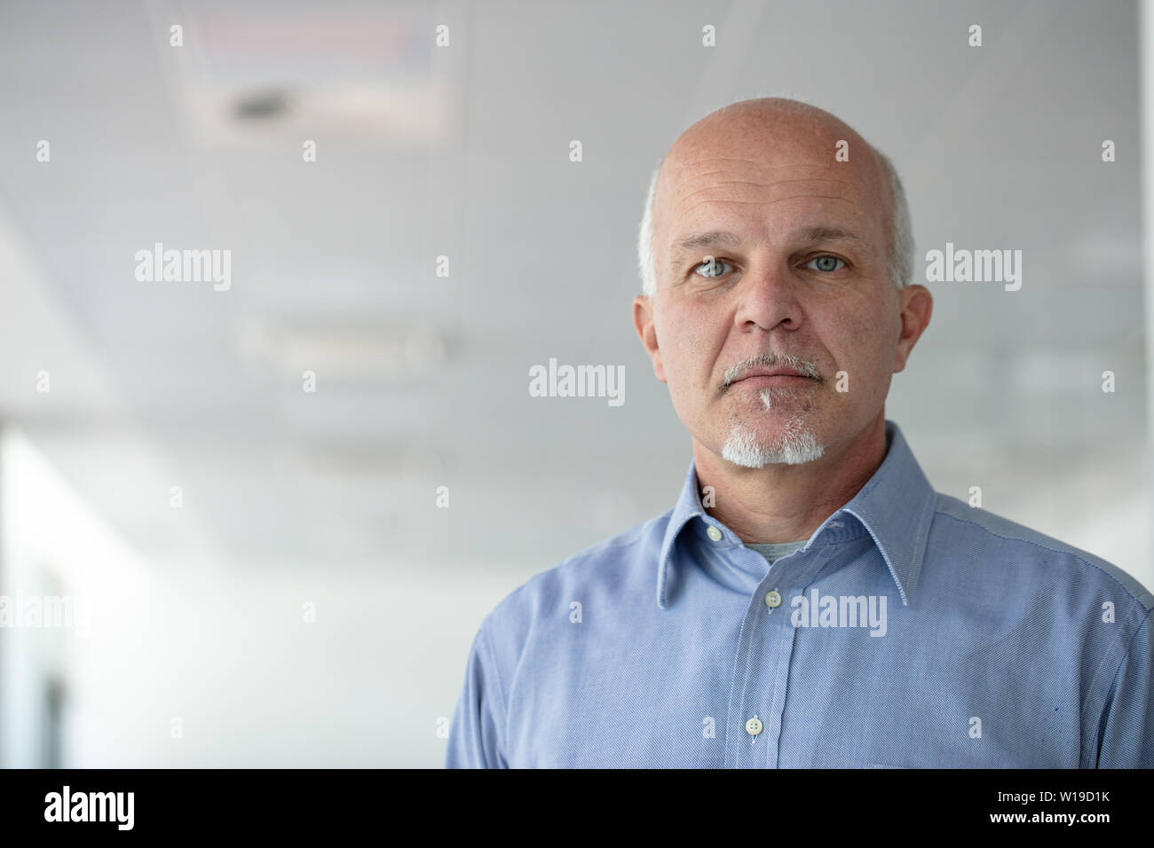 Serious senior man staring intently at the camera with a penetrating ...