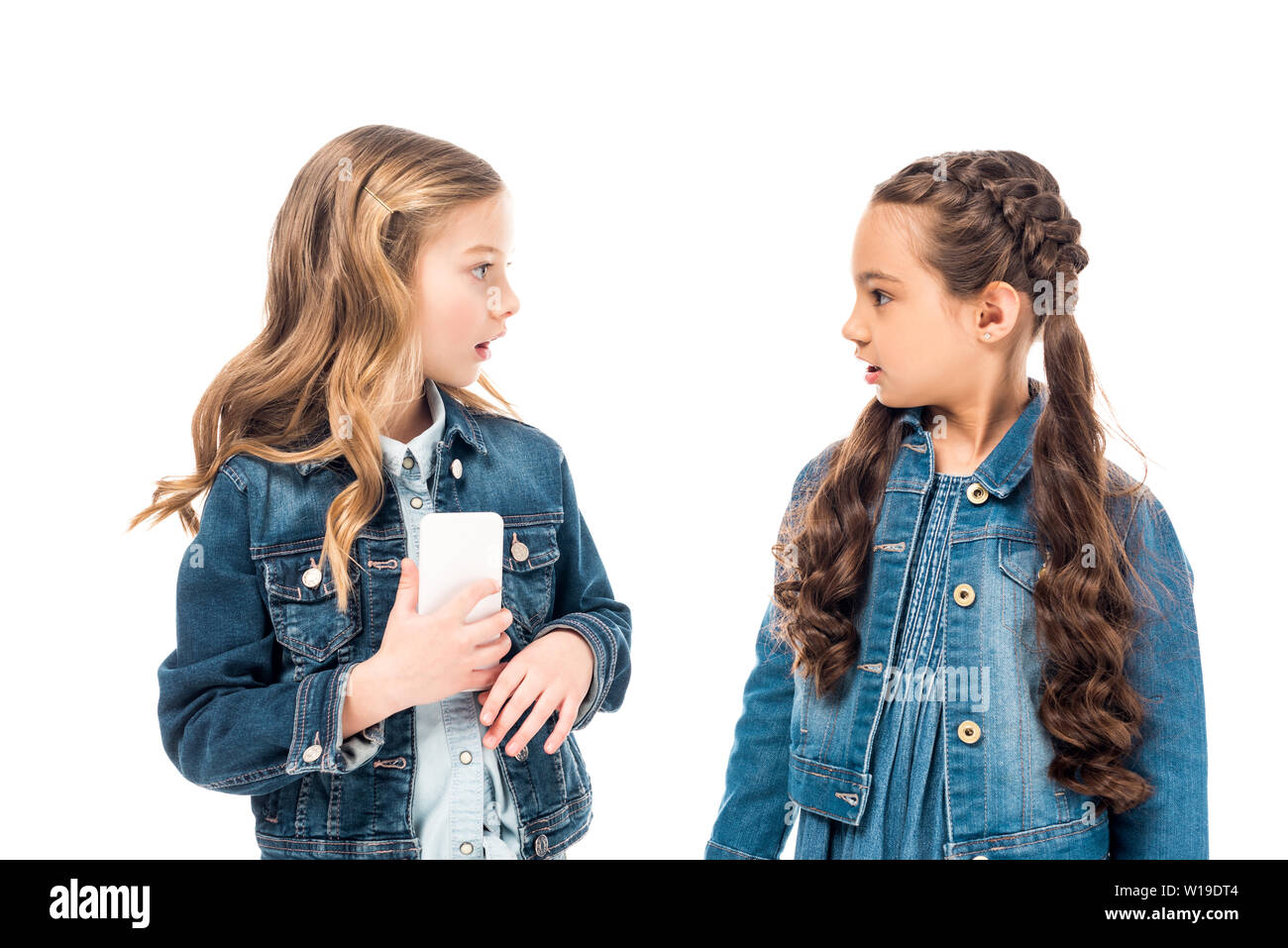 two surprised kids with smartphone looking at each other isolated on ...