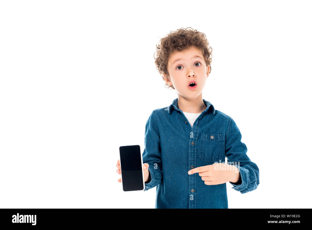 front view of shocked kid in denim shirt pointing with finger at ...