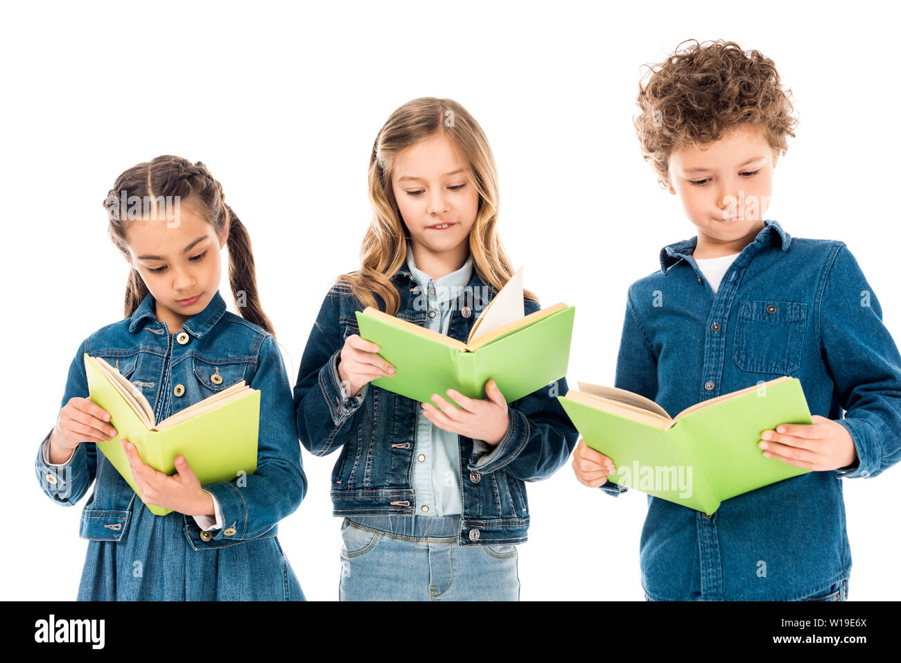 three concentrated kids in denim clothes reading books isolated on ...