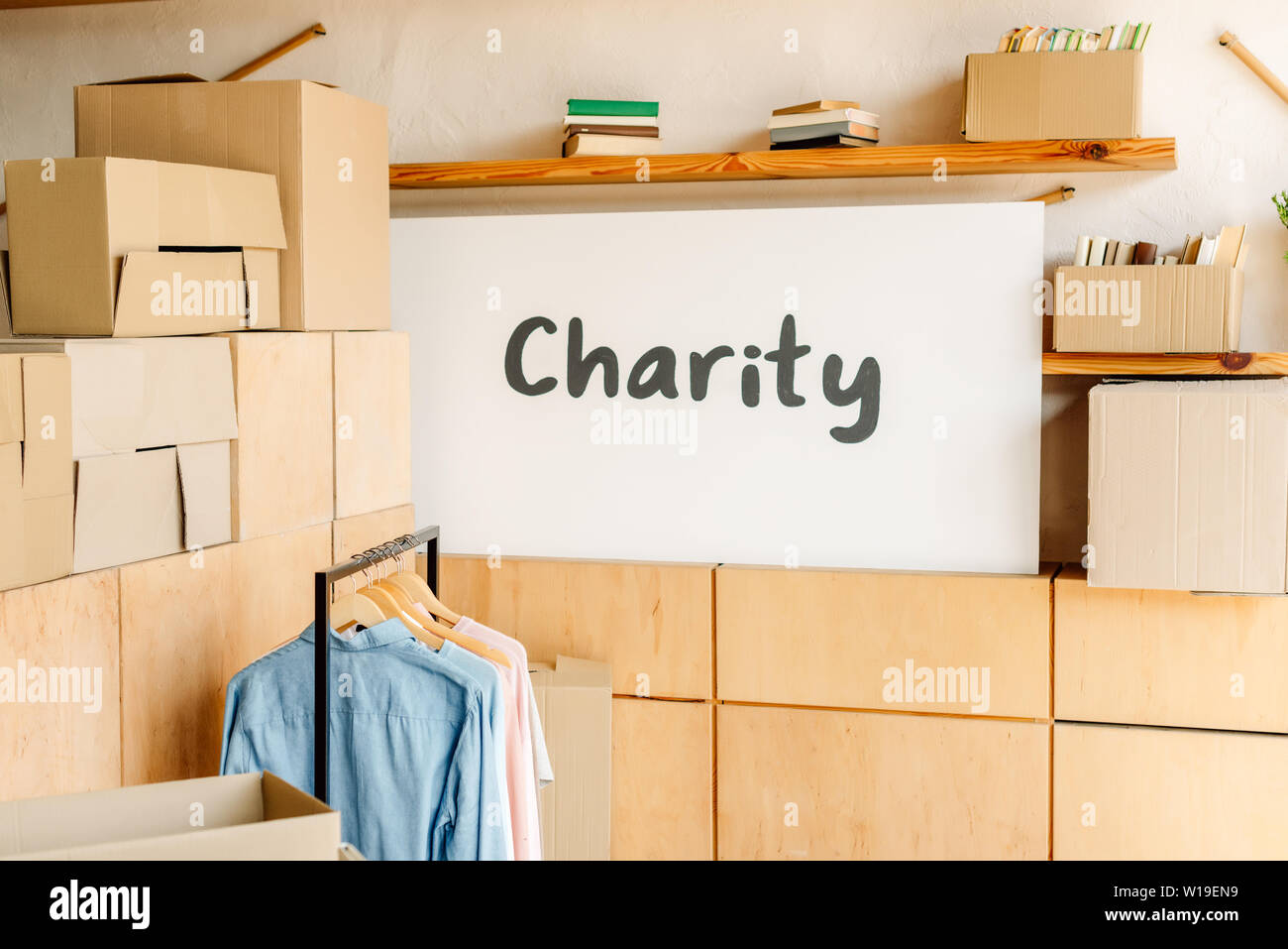 wooden cabinets, carton boxes, rack with shirts and placard with ...