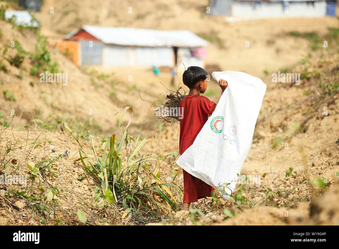 Child in red dress collecting firewood in Rohingya Refugee Camp ...