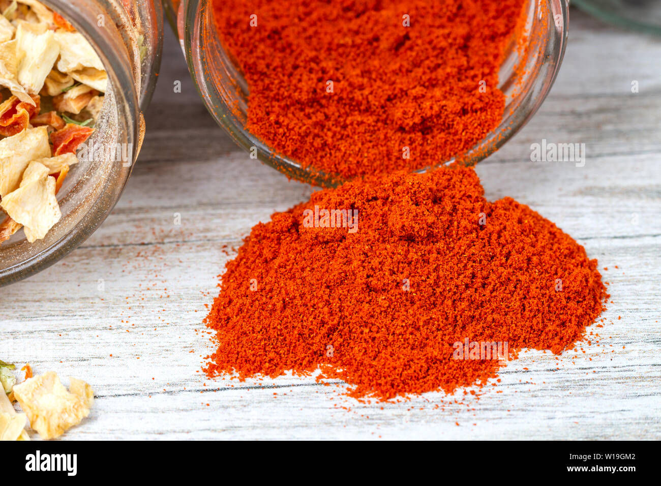 Spices pouring out of the jar. Dried ground paprika. Wooden background ...