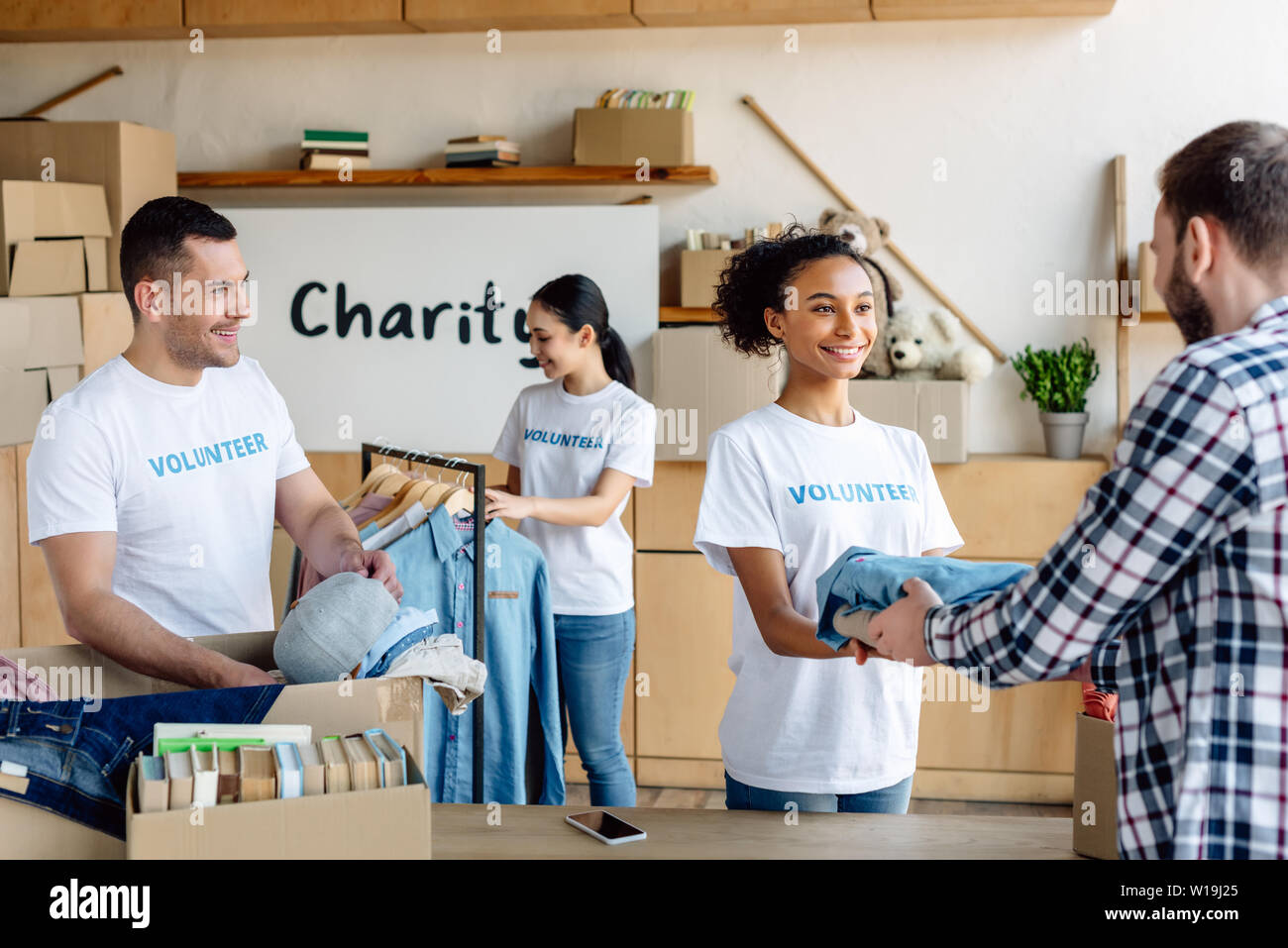 selective focus of pretty african american girl giving clothes to man ...