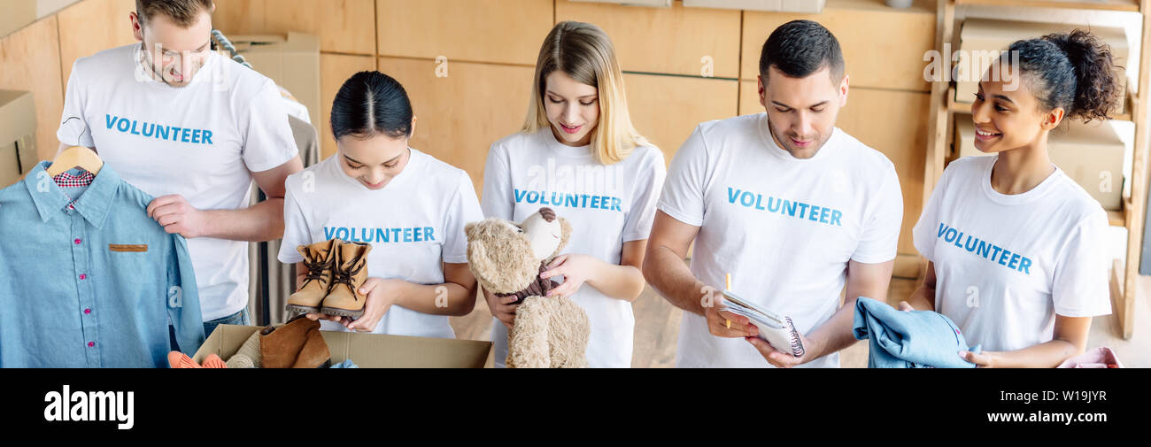 panoramic shot of young multicultural volunteers working together in ...