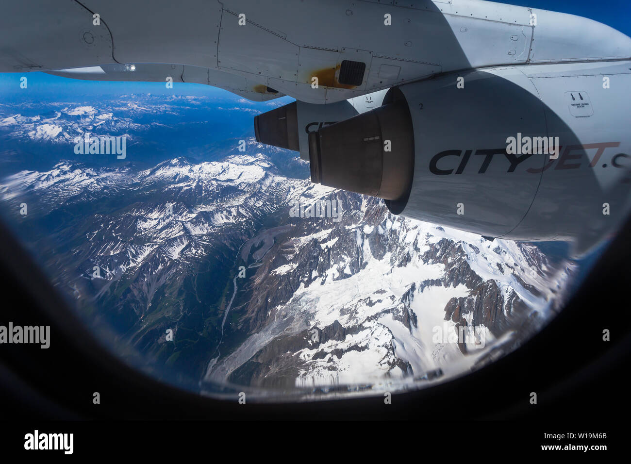 City Jet flying over the Alps from Italy into France Stock Photo - Alamy