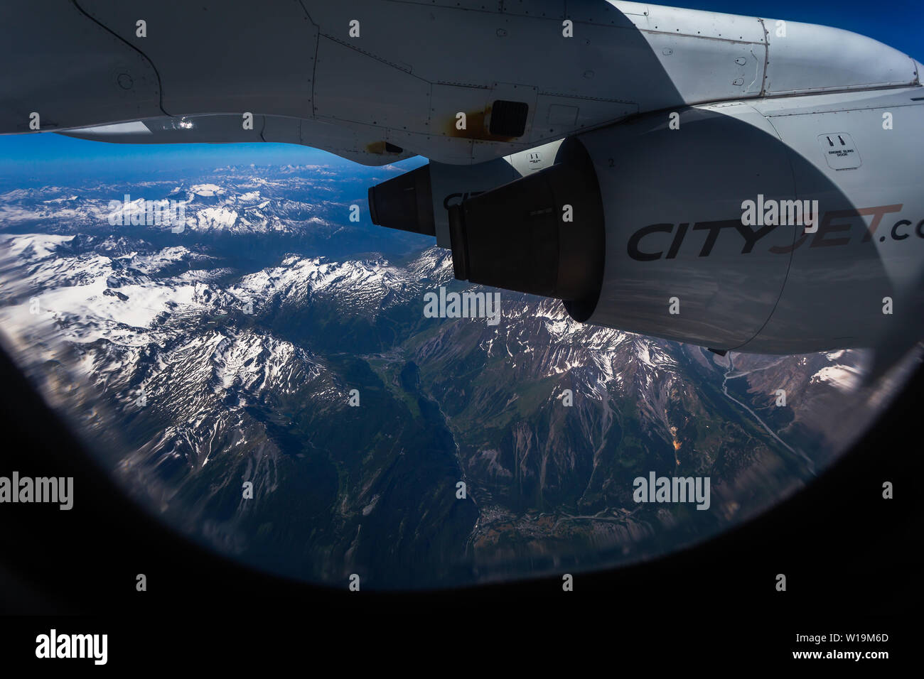 City Jet flying over the Alps from Italy into France Stock Photo - Alamy