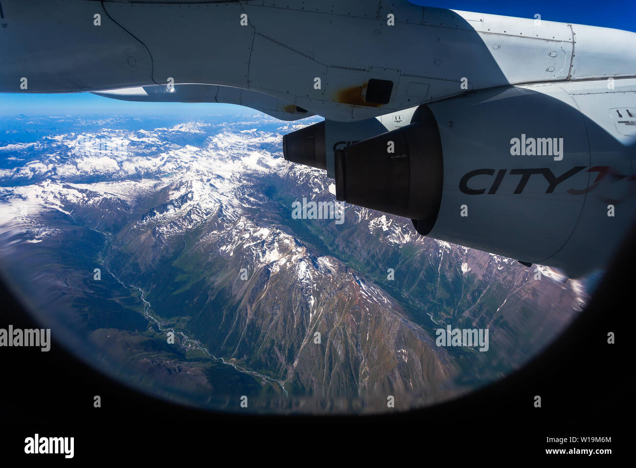 City Jet flying over the Alps from Italy into France Stock Photo - Alamy