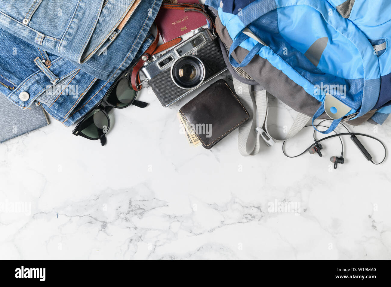 prepare backpack accessories and travel items for summer on marble ...