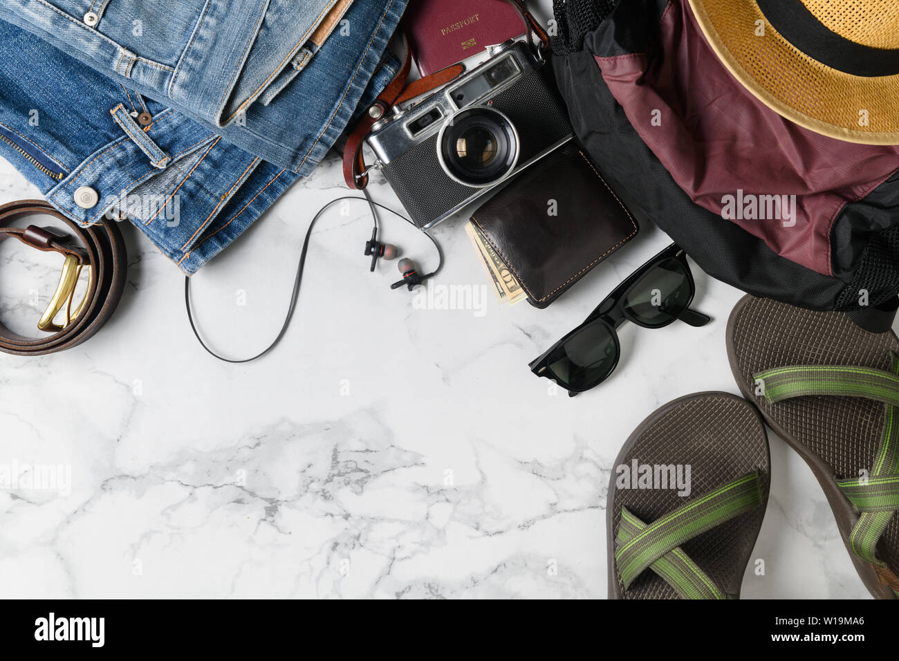 prepare backpack accessories and travel items for summer on marble ...