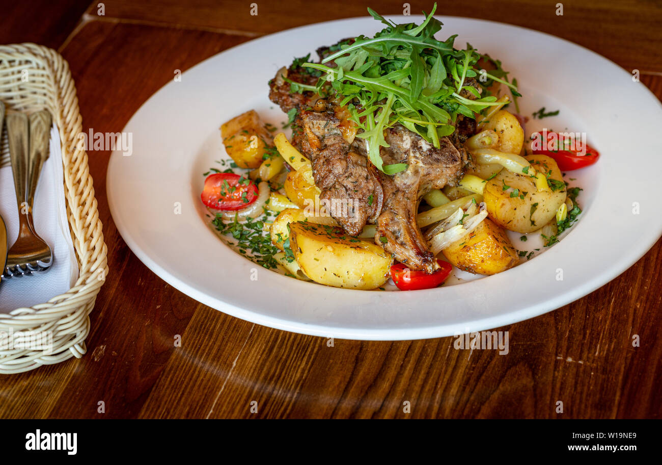 Roasted sheep meat with potatoes and beans Stock Photo - Alamy