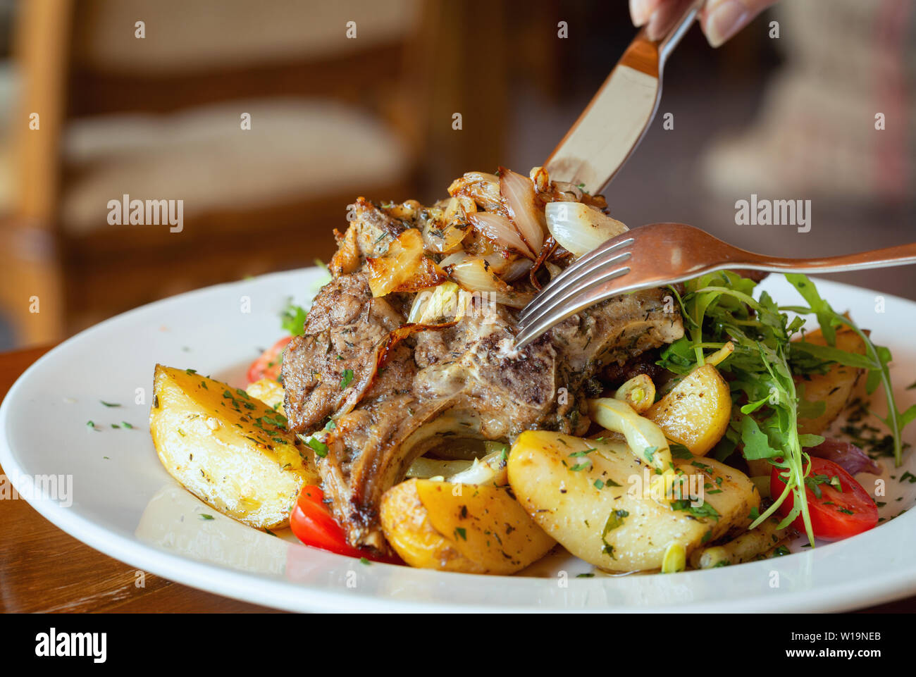 Roasted sheep meat with potatoes and beans Stock Photo - Alamy