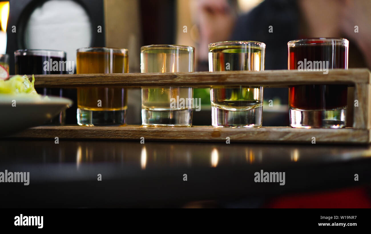 Multicolored transparent cocktails, a set of shots in one row, six ...