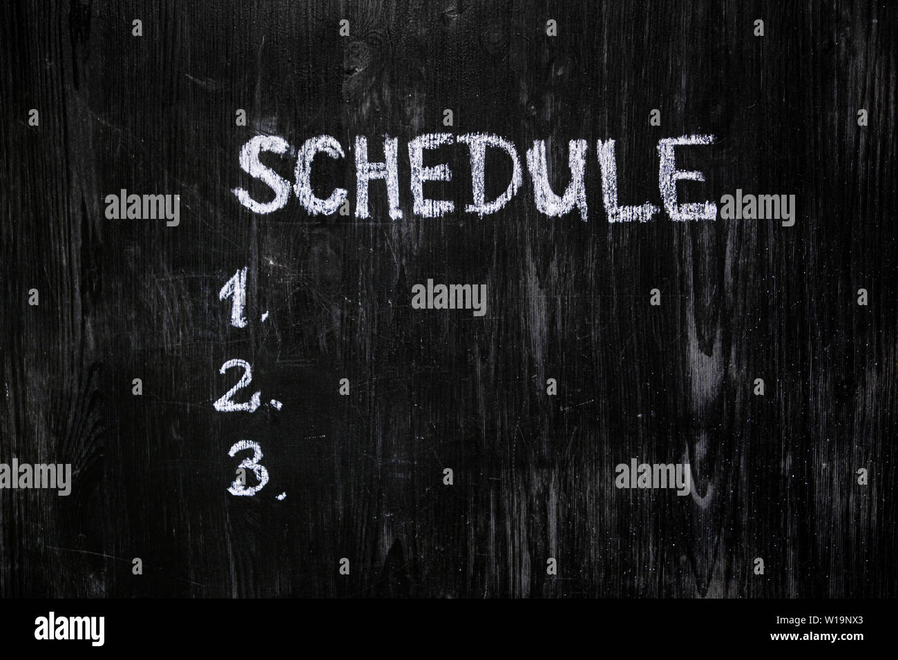 Schedule list handwritten with chalk on blackboard. Black wood ...