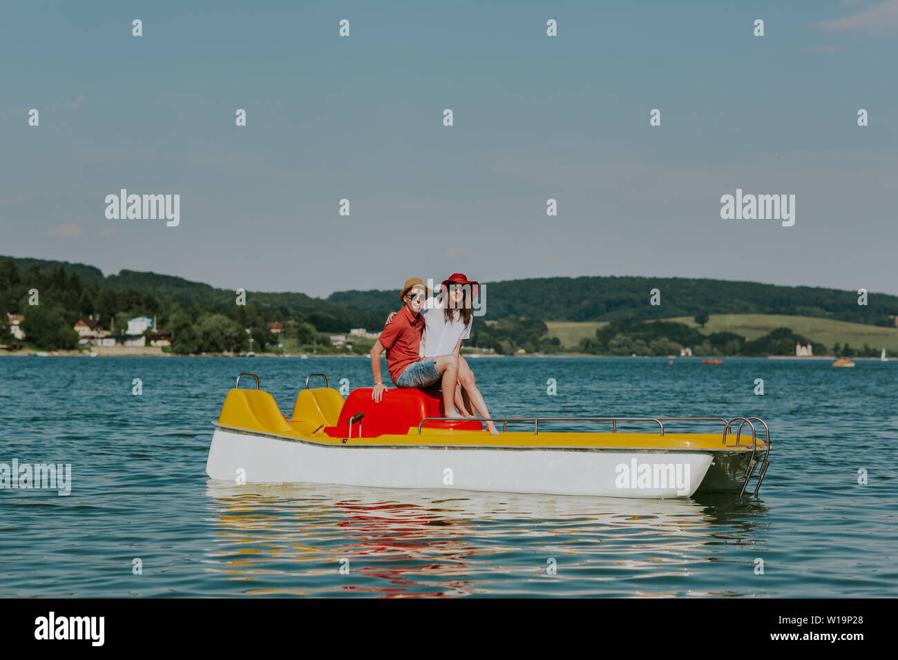 Portrait of smiling couple in love having fun pedal boating. Full ...