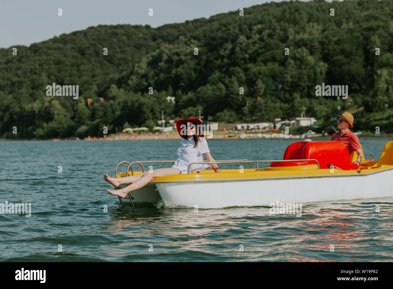 Couple in love enjoying boating in the lake. Portrait of young man and ...