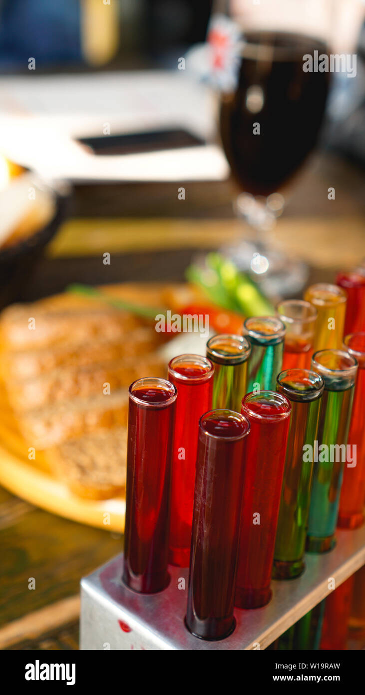 Test tubes with multi-colored liquid. Alcohol in test tubes dark bar ...