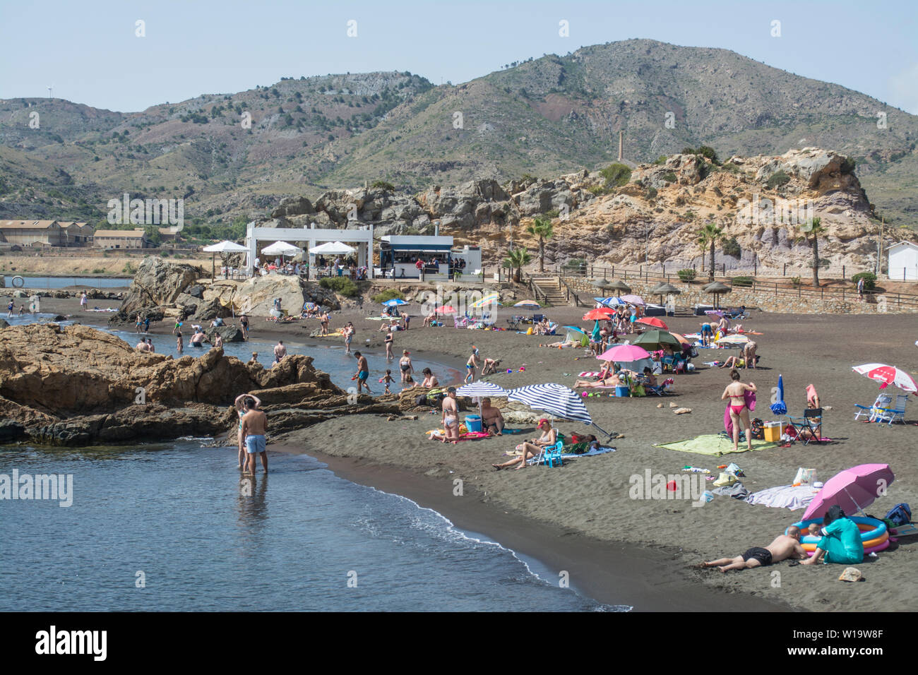 Sunbathers on the Black sand beach at Portman in Murcia, Spain Stock ...