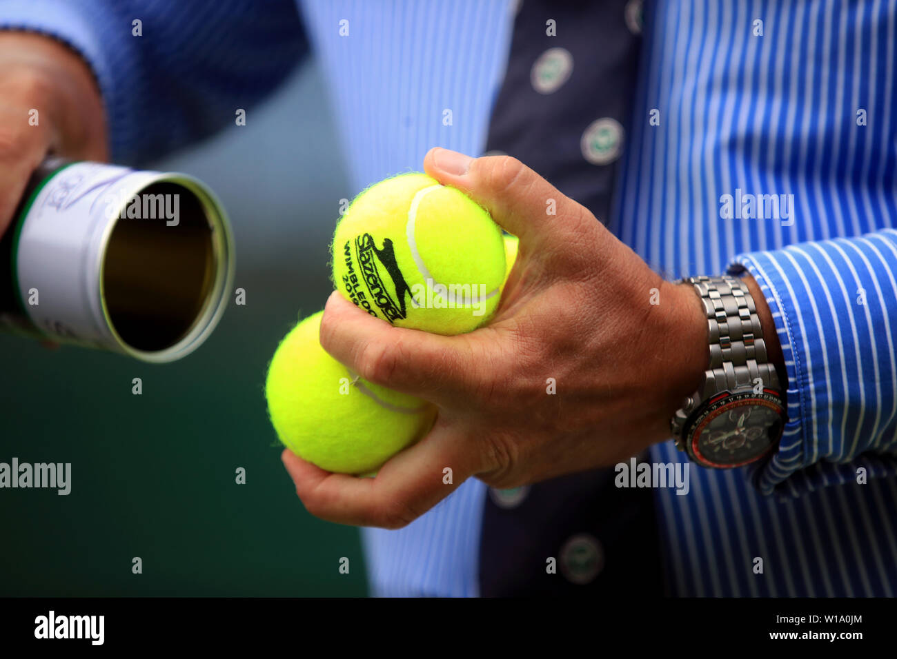 A line judge removes new balls from a canister on day one of the ...