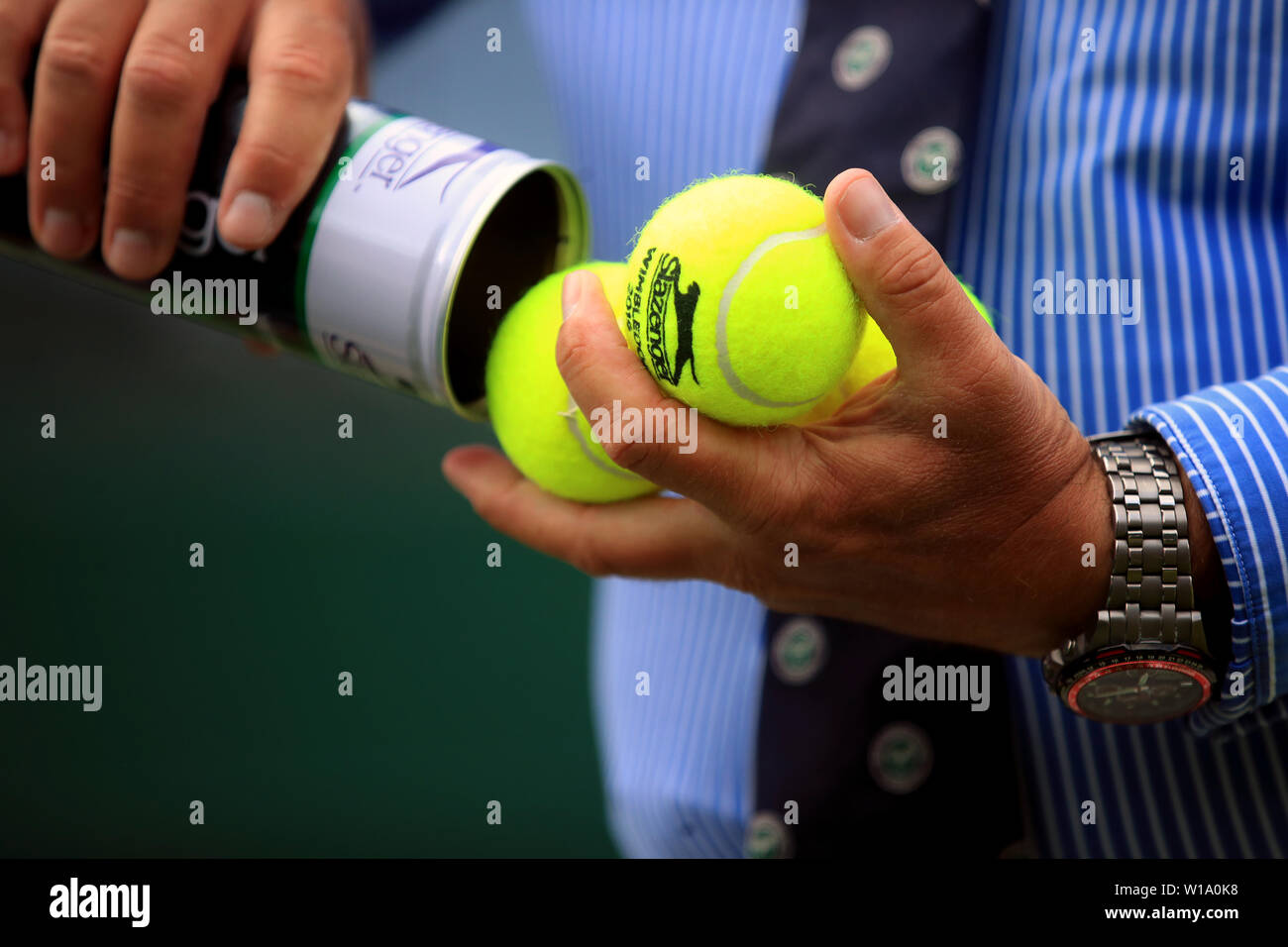 A line judge removes new balls from a canister on day one of the ...