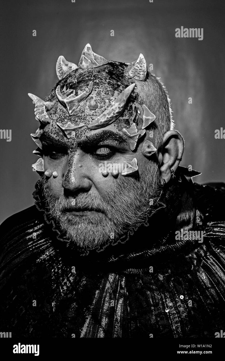 Demon with golden collar on black background. Man with thorns or warts ...