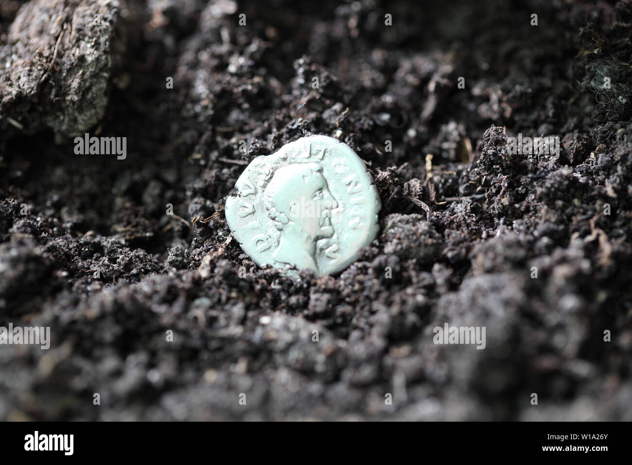Silver denarius in the ground Stock Photo - Alamy