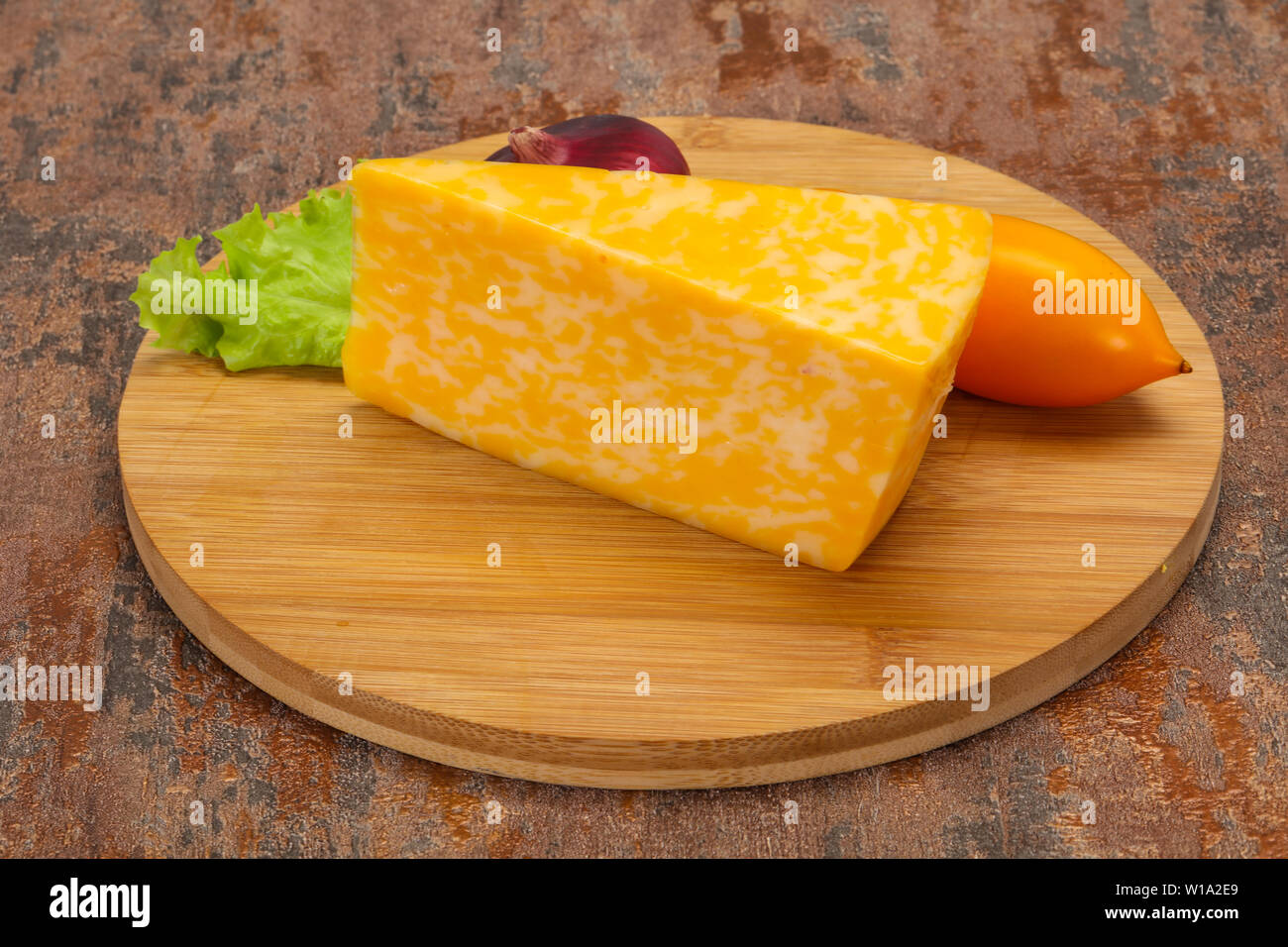 Marble cheese triangle over wooden background Stock Photo - Alamy