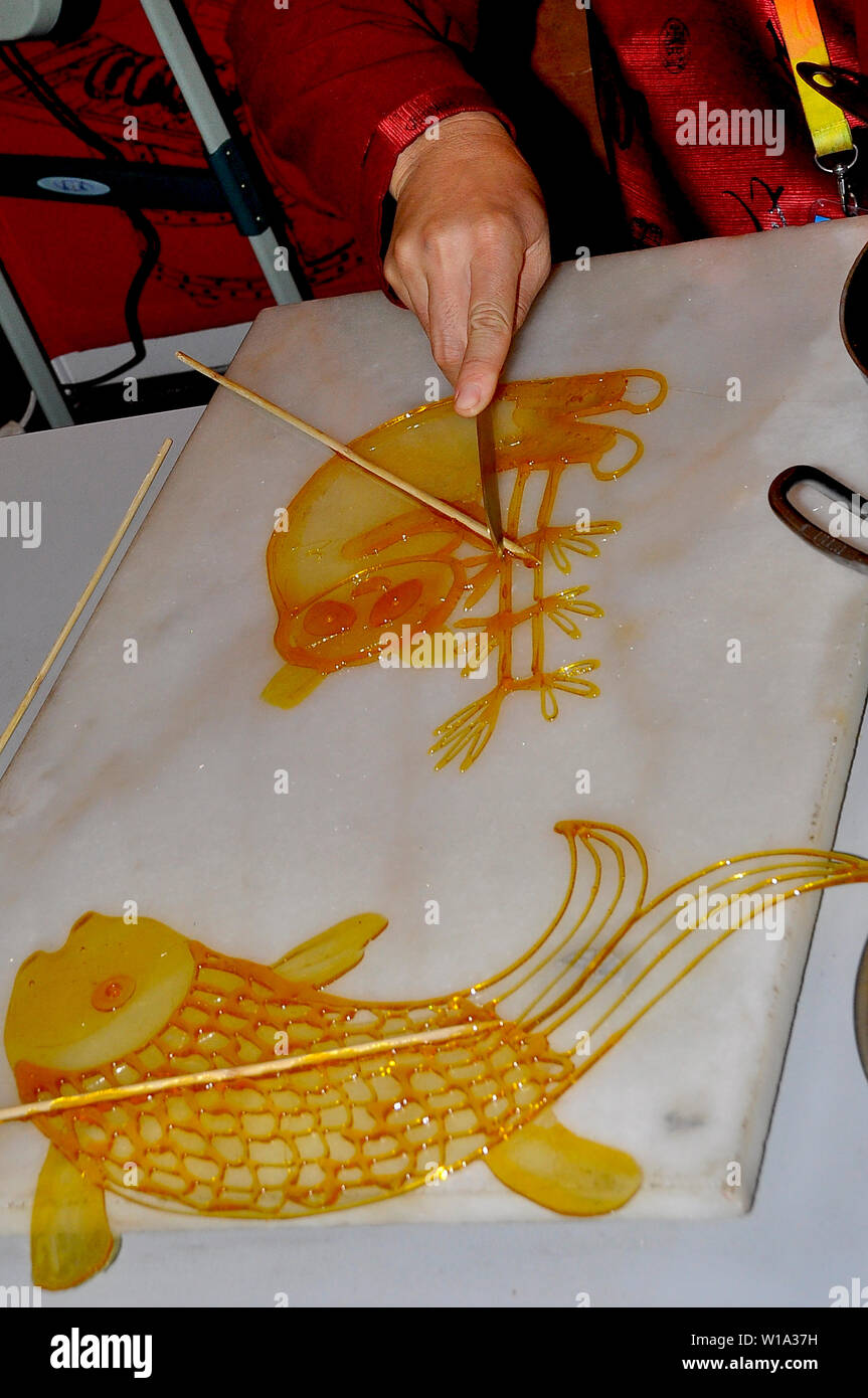 Fish drawn using molten sugar, a sweet treat fro Chinese children Stock ...