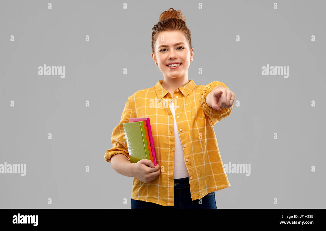 teenage student girl with books pointing to you Stock Photo - Alamy
