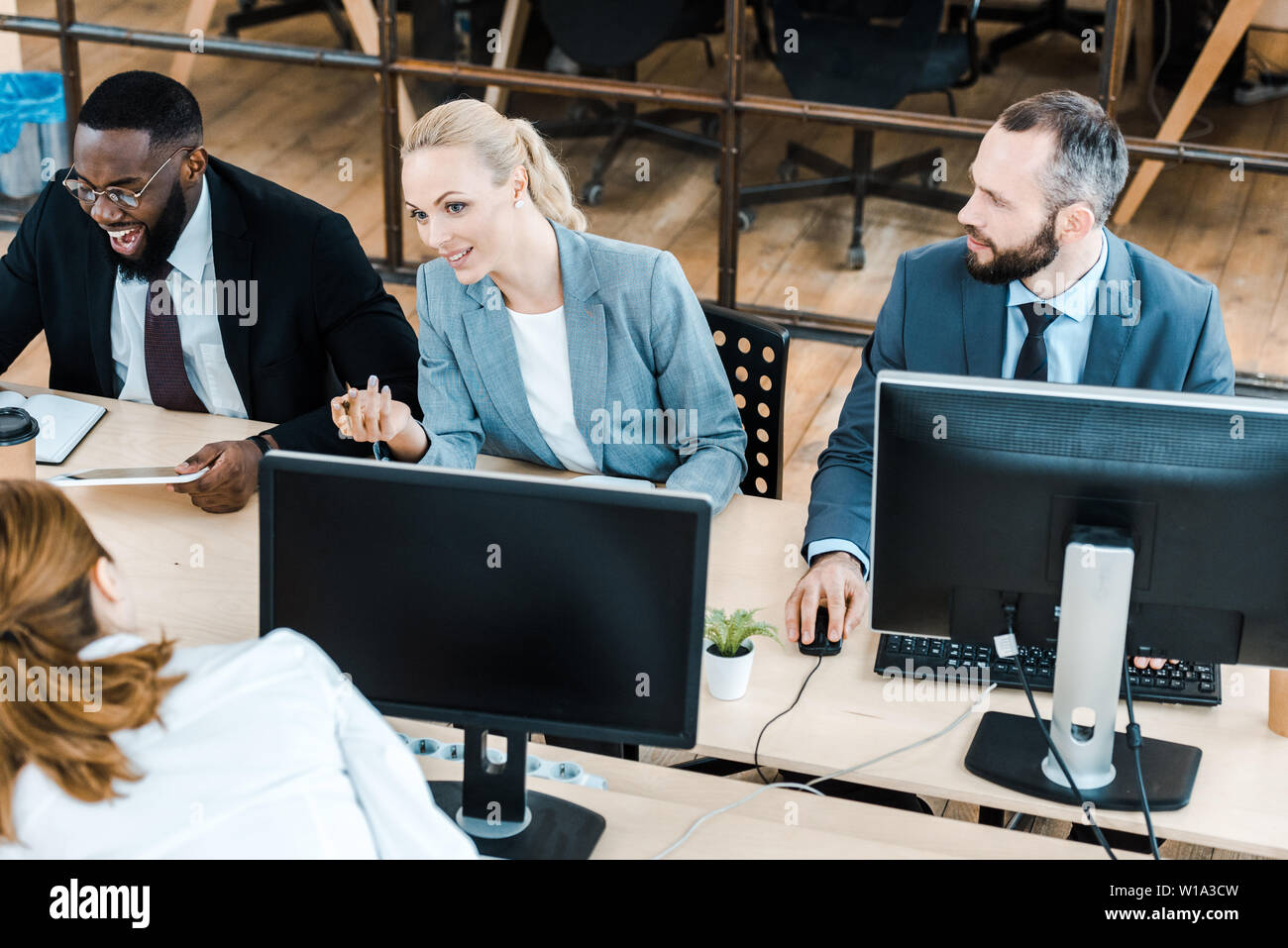 attractive businesswoman gesturing and talking with multicultural ...
