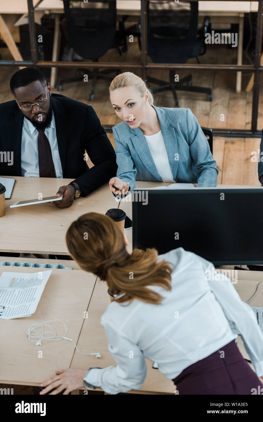 attractive blonde businesswoman gesturing while talking with ...