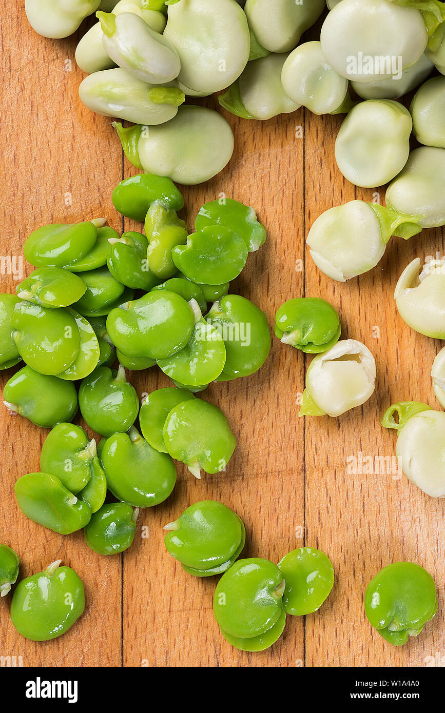 Peeled and un peeled broad beans on a wooden chopping board Stock Photo ...