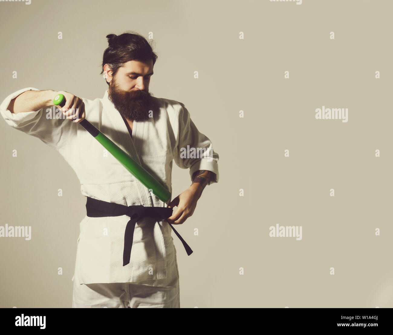 bearded serious karate man in kimono with green baseball bat Stock ...