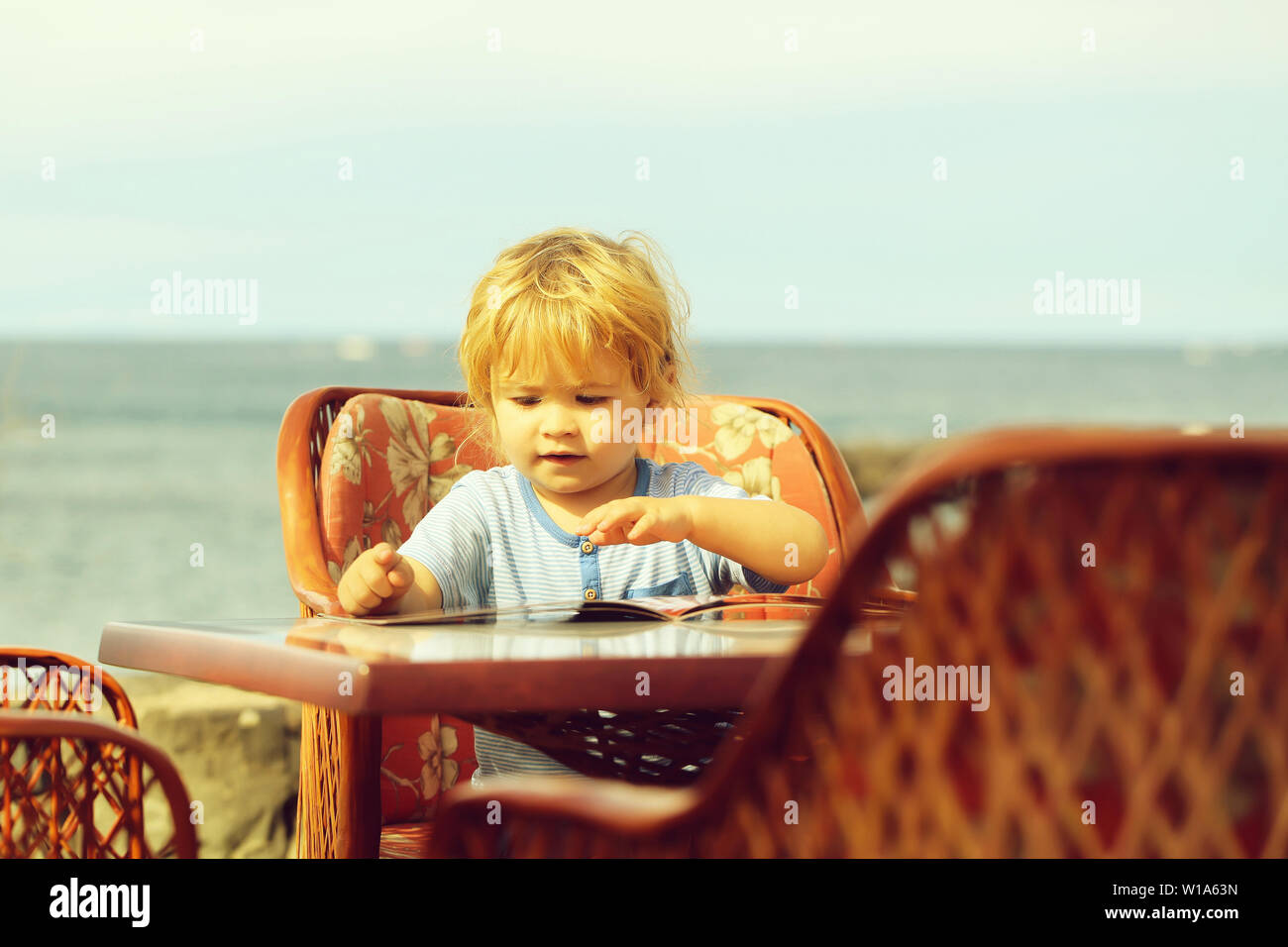 Cute baby boy reads menu card Stock Photo - Alamy