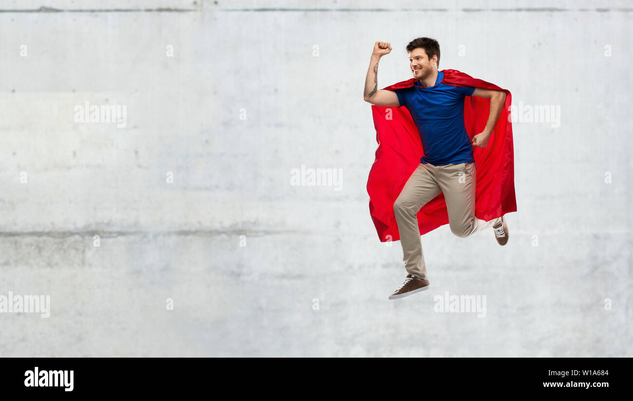 man in red superhero cape jumping over concrete Stock Photo - Alamy