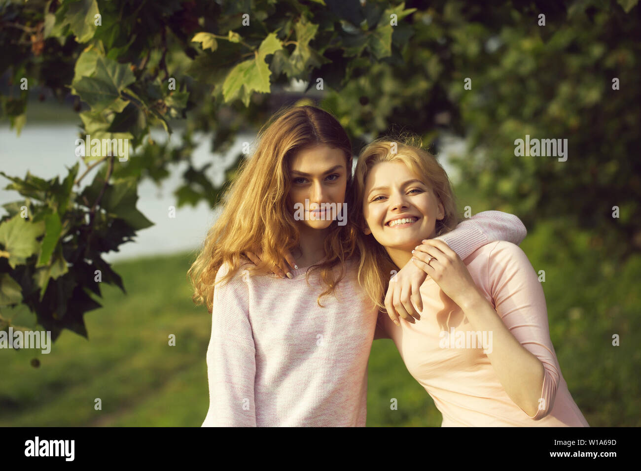 Two girls hug and smile Stock Photo - Alamy