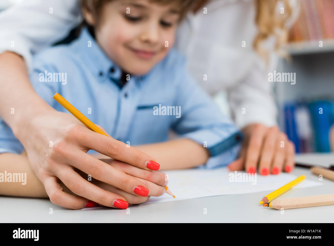 selective focus of woman drawing with happy kid Stock Photo - Alamy