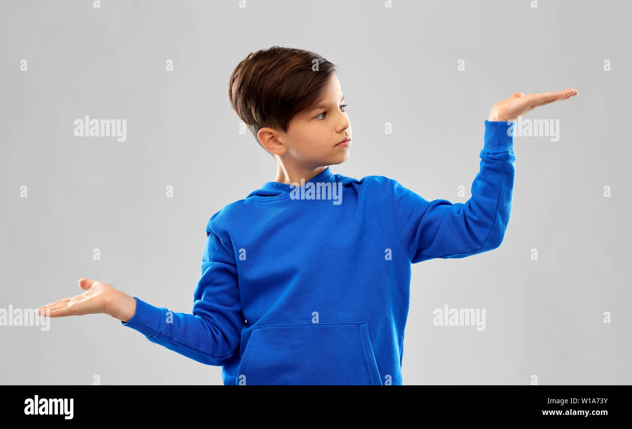 boy in blue holding something on empty hands Stock Photo - Alamy