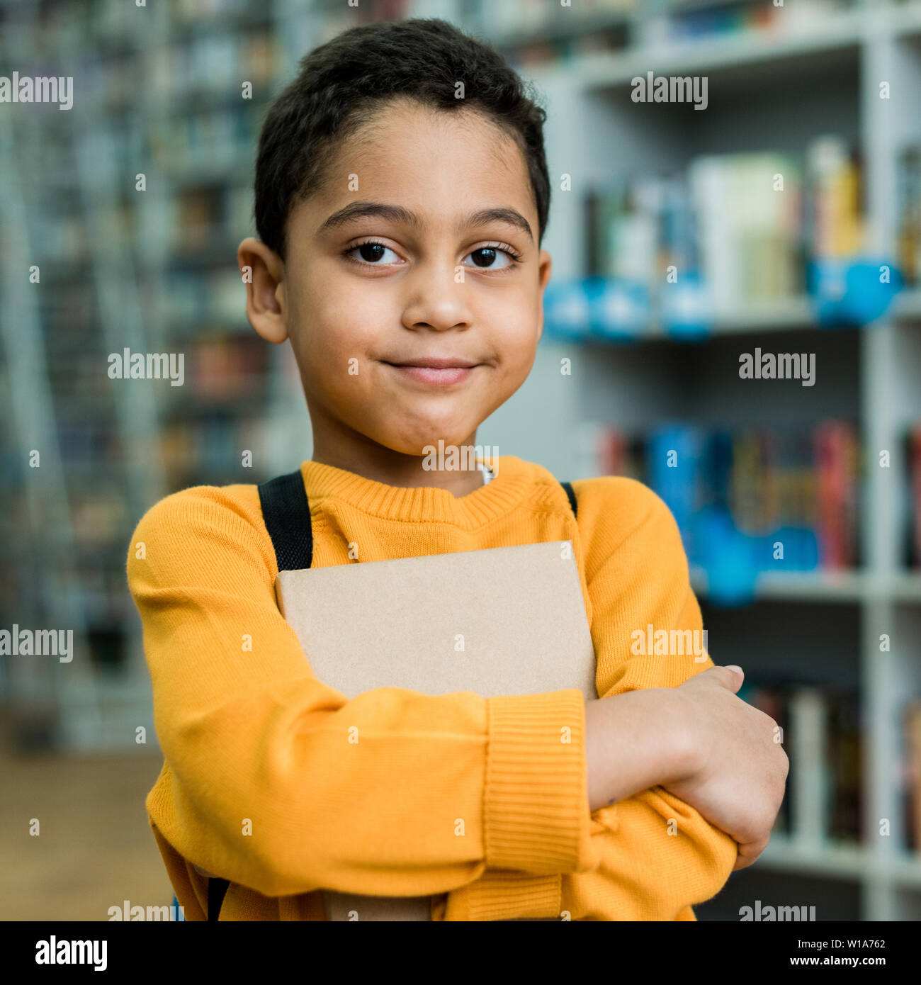 cute african american boy smiling while holding book Stock Photo - Alamy