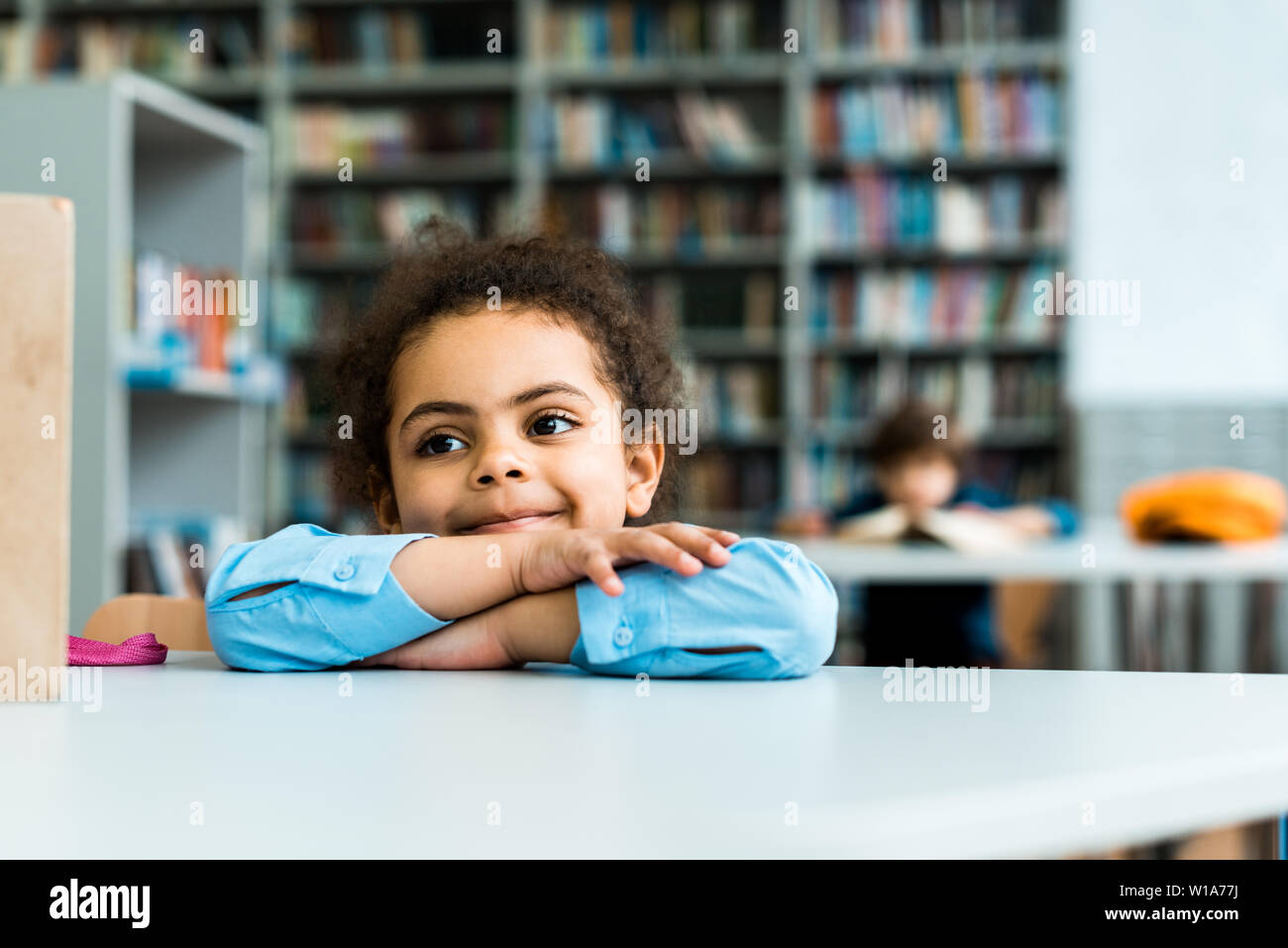Happy child in library girl hi-res stock photography and images - Alamy