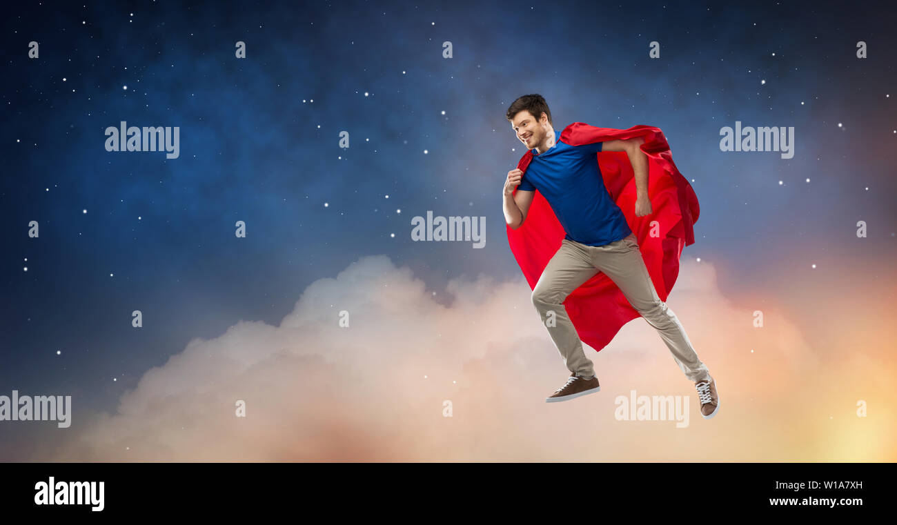 man in red superhero cape flying over night sky Stock Photo - Alamy