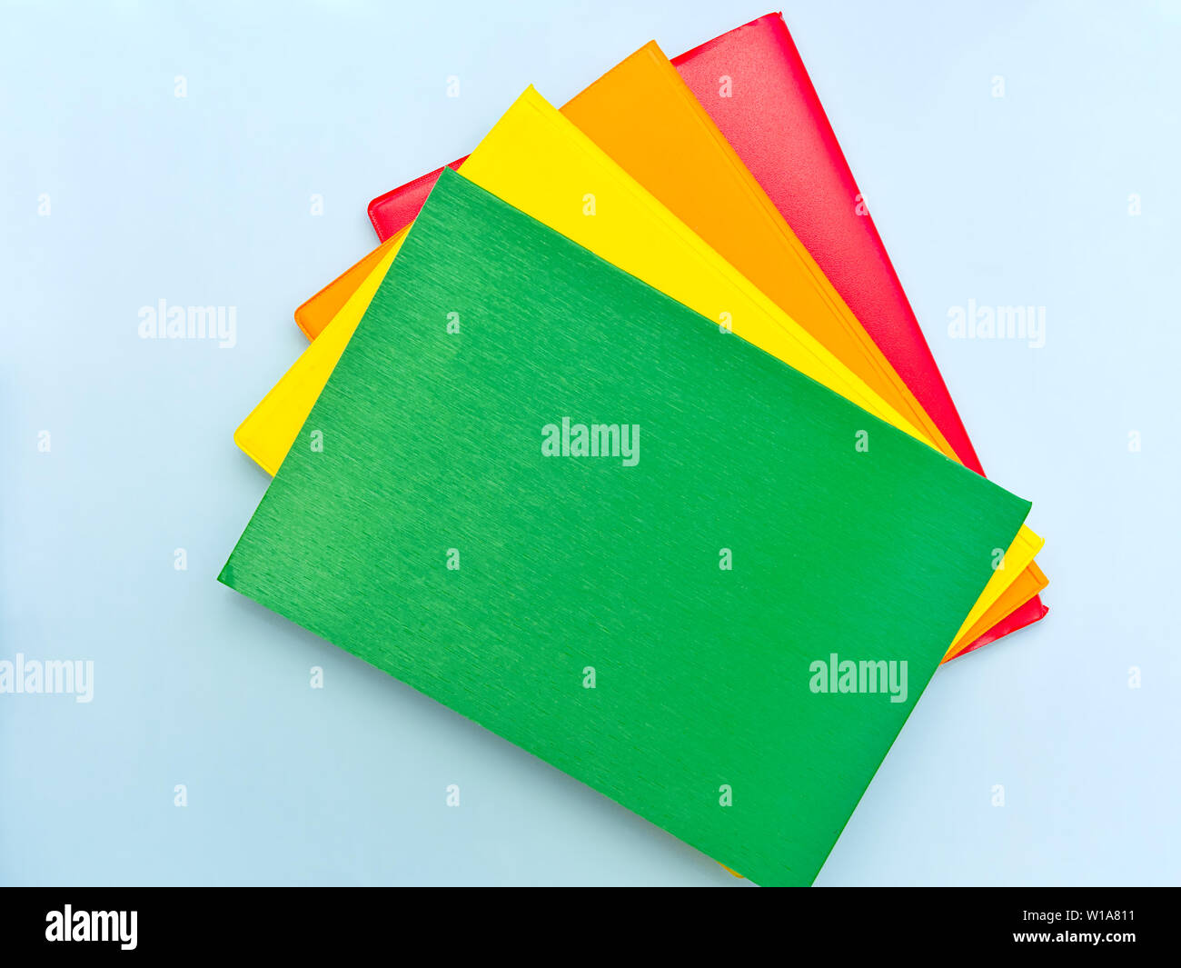 Colorful stacked notebooks on light blue background Stock Photo - Alamy