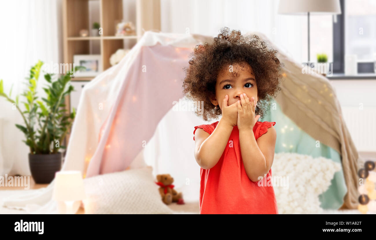 confused african american girl covering mouth Stock Photo - Alamy